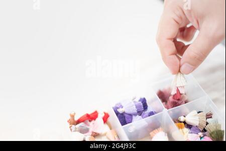 Hand holding multicolor tassel choosing for decorating with many things ...