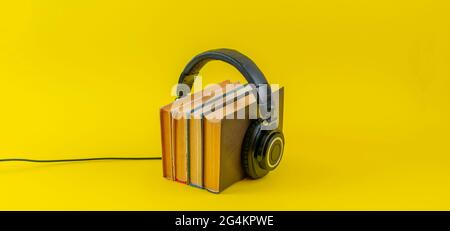 listen to the audio books concept, big headphones put on the stack of ...
