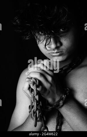 Grayscale shot of a chained up guy Stock Photo - Alamy