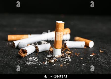 Many cigarettes on dark background Stock Photo - Alamy