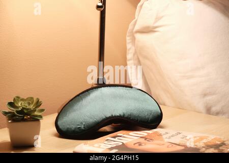 Stylish sleeping mask on table in bedroom Stock Photo - Alamy