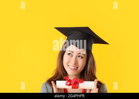 Thoughtful graduating student on color background Stock Photo - Alamy