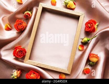 Beige wooden frame mockup with red rose in glass and white coffee cup ...