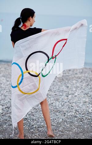 Kemer, Turkey - June 16, 2021: Woman is covered with the Olympic flag ...