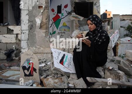 Rafah, Gaza. 23rd June, 2021. Palestinian artist Saja Moussa, 26, draws ...