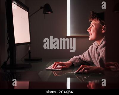 Smiling Boy using Computer Stock Photo - Alamy