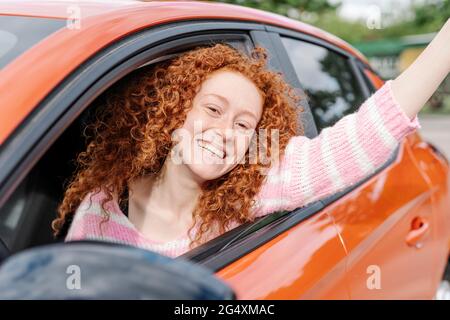 Redhead curly hair woman sitting on a bench in the park Stock Photo - Alamy