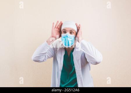 Excited handsome man in protective mask pointing fingers upward ...