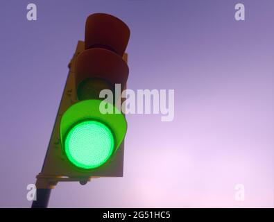 Vertical traffic light with red yellow and green signals illuminated in ...