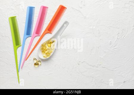 Hair combs, fish oil pills and houseplant on light background Stock ...