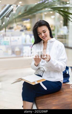 Positive woman sitting at hall at office Stock Photo - Alamy