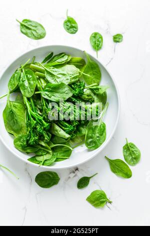 Organic spinach with broccolini (bimi) in bowl on white background ...