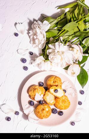 Profiteroles with blueberries. Custard cakes, Eclair, cream puff ...