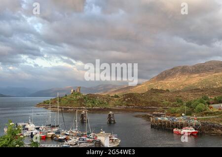 Old boat in old harbour with Kyleakin Castle in background, Isle of ...