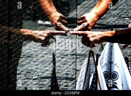 Pointing fingers find a name on the Vietnam War Memorial in Washington ...