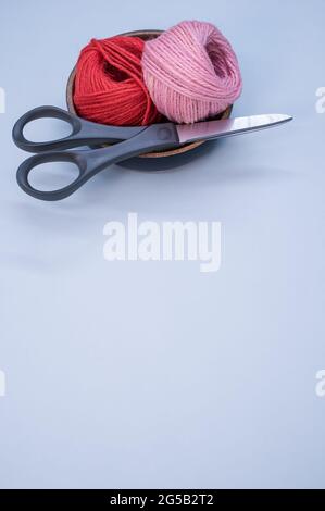Vertical shot of scissors and cotton yarn on a pink surface - copy ...