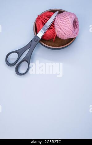 Vertical shot of scissors and cotton yarn on a pink surface - copy ...