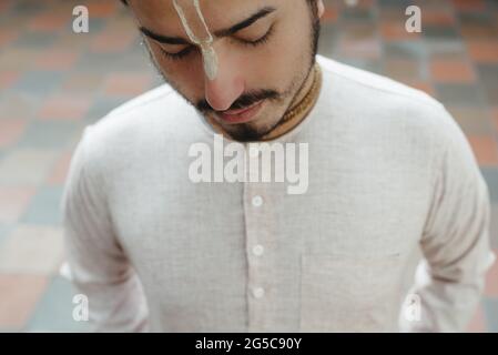 Ecuadorian young man with a mark on his forehead doing a praying pose ...