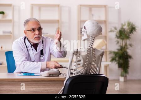 Skeleton patient visiting old male doctor radiologist Stock Photo - Alamy