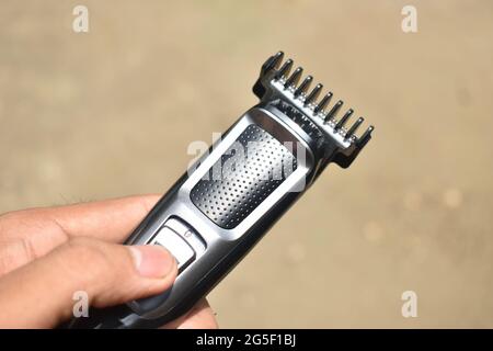 A closeup of a black clipper on a man's hand Stock Photo - Alamy