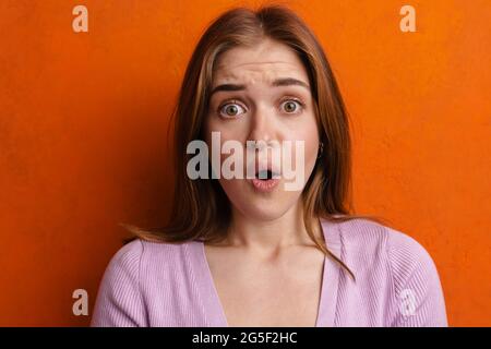 Young ginger shock woman expressing surprise at camera isolated over ...