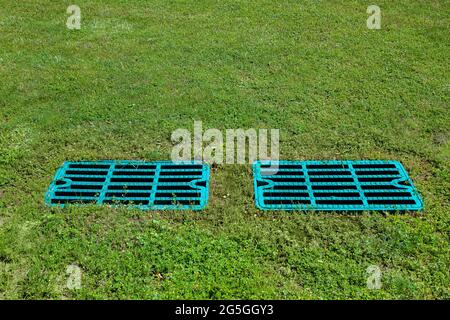 2 manhole drainage grates on the lawn with green grass septic tank ...