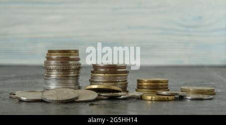 Coins from different countries are stacked on top of each other. An ...