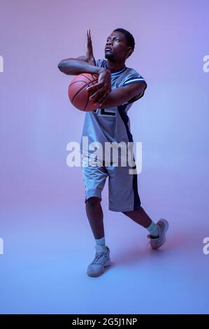 Strong basketball player hand holds ball in studio, black background ...