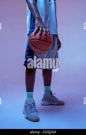 Strong basketball player hand holds ball in studio, black background ...