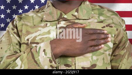 Composition of midsection of male soldier with hand on heart, against ...