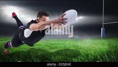 Composition of male rugby player catching rugby ball on black ...