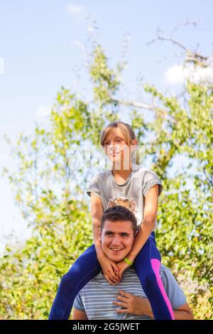 Sister giving brother piggyback ride in studio Stock Photo - Alamy