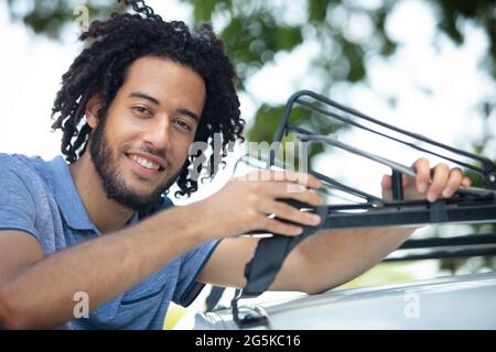 man install roof bar on his car Stock Photo - Alamy