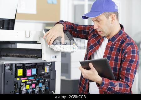 middle age man fixing a printer Stock Photo - Alamy