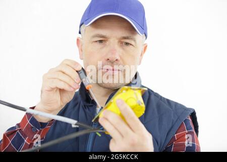 Person performs electrical wiring by connecting green and other wires ...