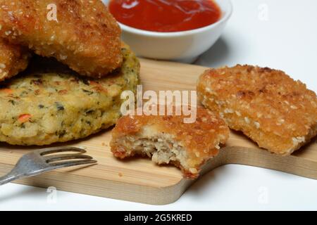 Meat substitute on wooden board and tray with ketchup, imitation meat ...