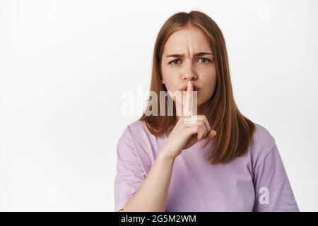 Hushing blond woman Stock Photo - Alamy
