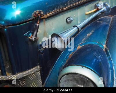 Fragment of an old blue car with a dirty rusted wheel and a scratched ...