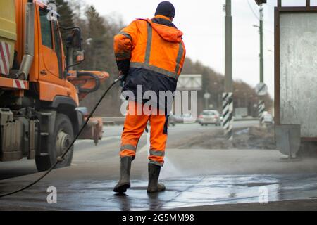 Cleaning up the public place. A jet of water washes the asphalt ...