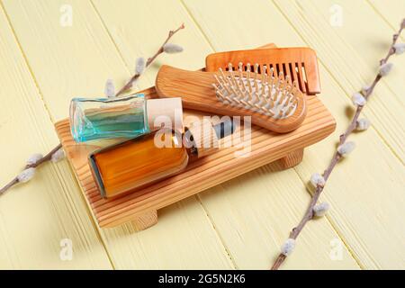 Composition with hair brush, comb and cosmetics on color background ...