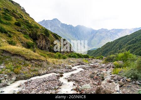 A seething river against the backdrop of mountains and sky Stock Photo ...