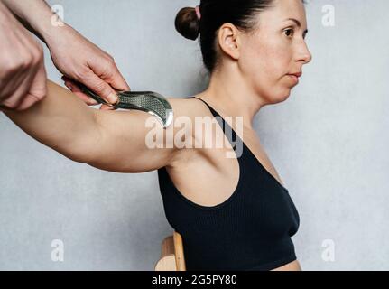 IASTM treatment for myofascial restriction, a woman receiving soft ...