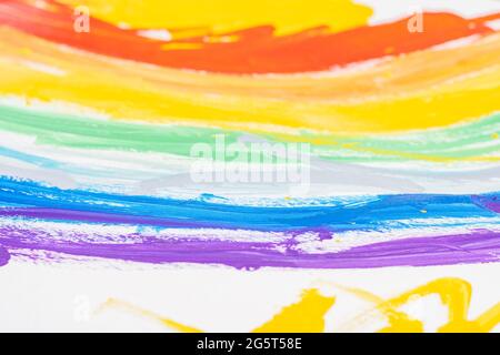 Top view child is drawing rainbow with watercolors on the sheet of ...