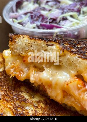 Golden brown grilled cheese sandwich on plate with cheese pull, chutney ...