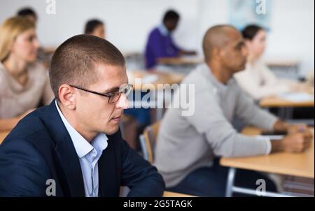Attentive students at their desks in university auditorium Stock Photo ...