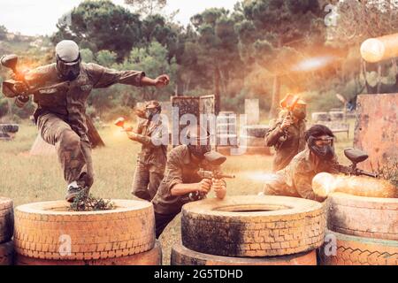 Two active opposing teams with guns playing paintball Stock Photo - Alamy