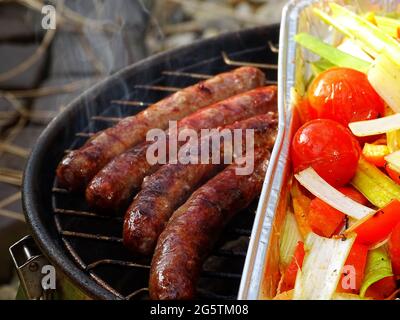 four beef chipolata sausages on the BBQ Stock Photo - Alamy
