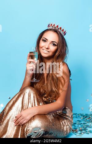 Champagne glass with beautiful golden confetti in shape of star on blue ...