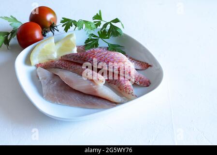 Fresh gurnard fillet with lemon on white plate Stock Photo - Alamy