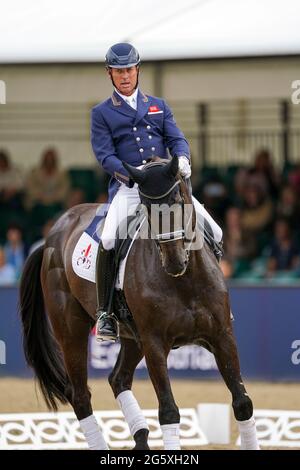 Britain's Carl Hester, riding En Vogue, tips his hat after competing in ...